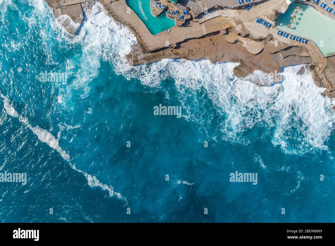 Aerial view of Ploce beach with swimming pool and stormy waves on the ...
