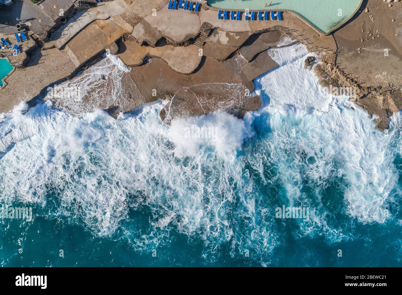 Aerial view of Ploce beach with swimming pool and stormy waves on the ...