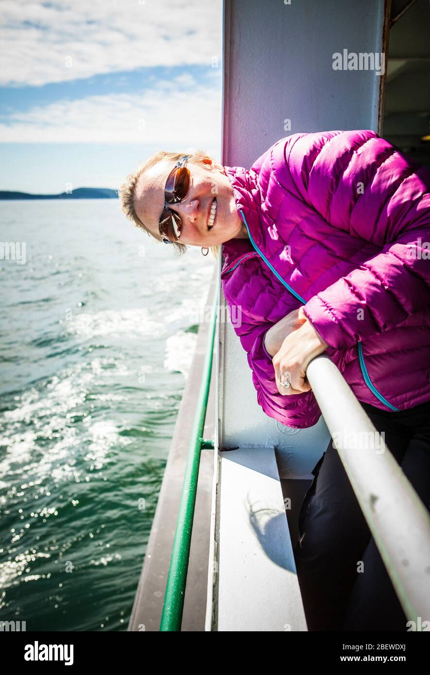 A woman leaning over the rail on a Washington State Ferry, Salish Sea ...
