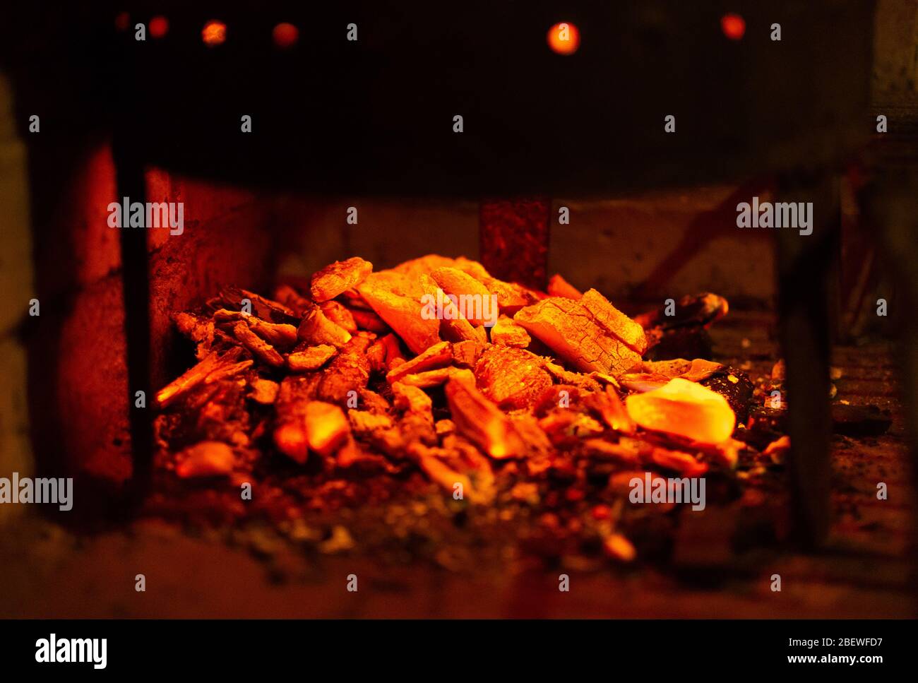 Red hot coals burning ready to be placed under the grill and cooking a ...