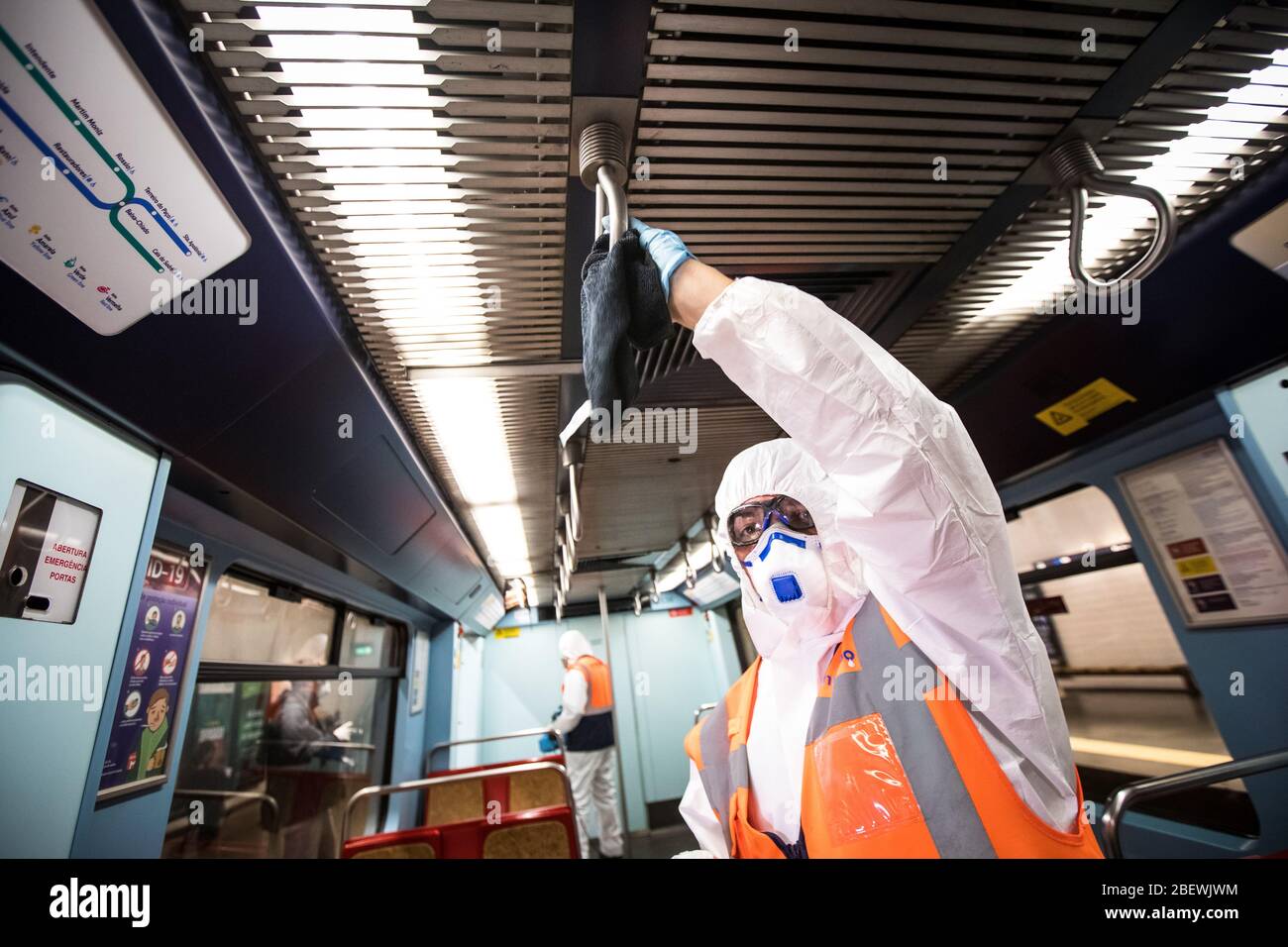 Employee equipped with the recommended protective materials, disinfects ...