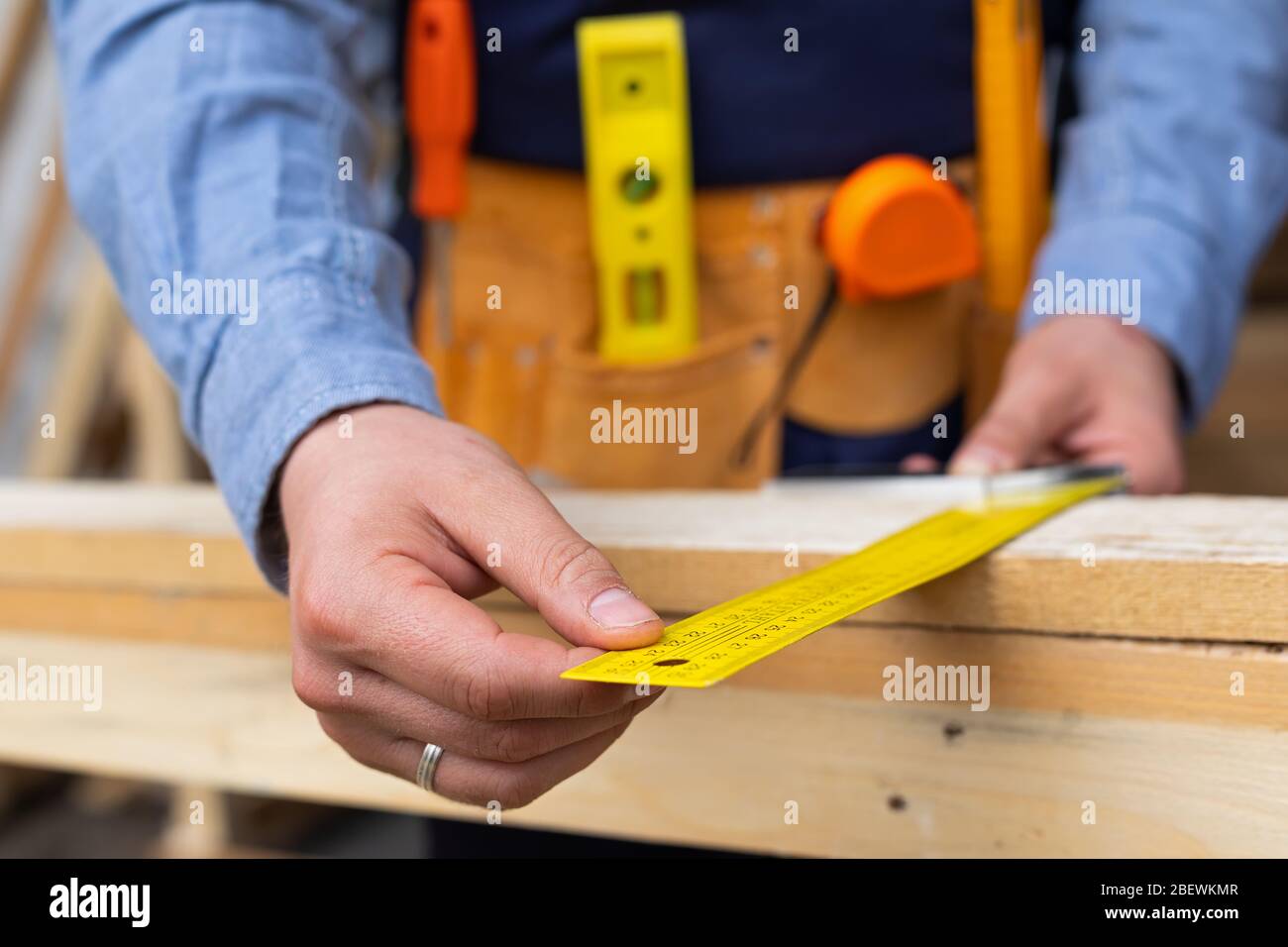 Close up picture of carpenters hands measuring plank - DIY renovation ...