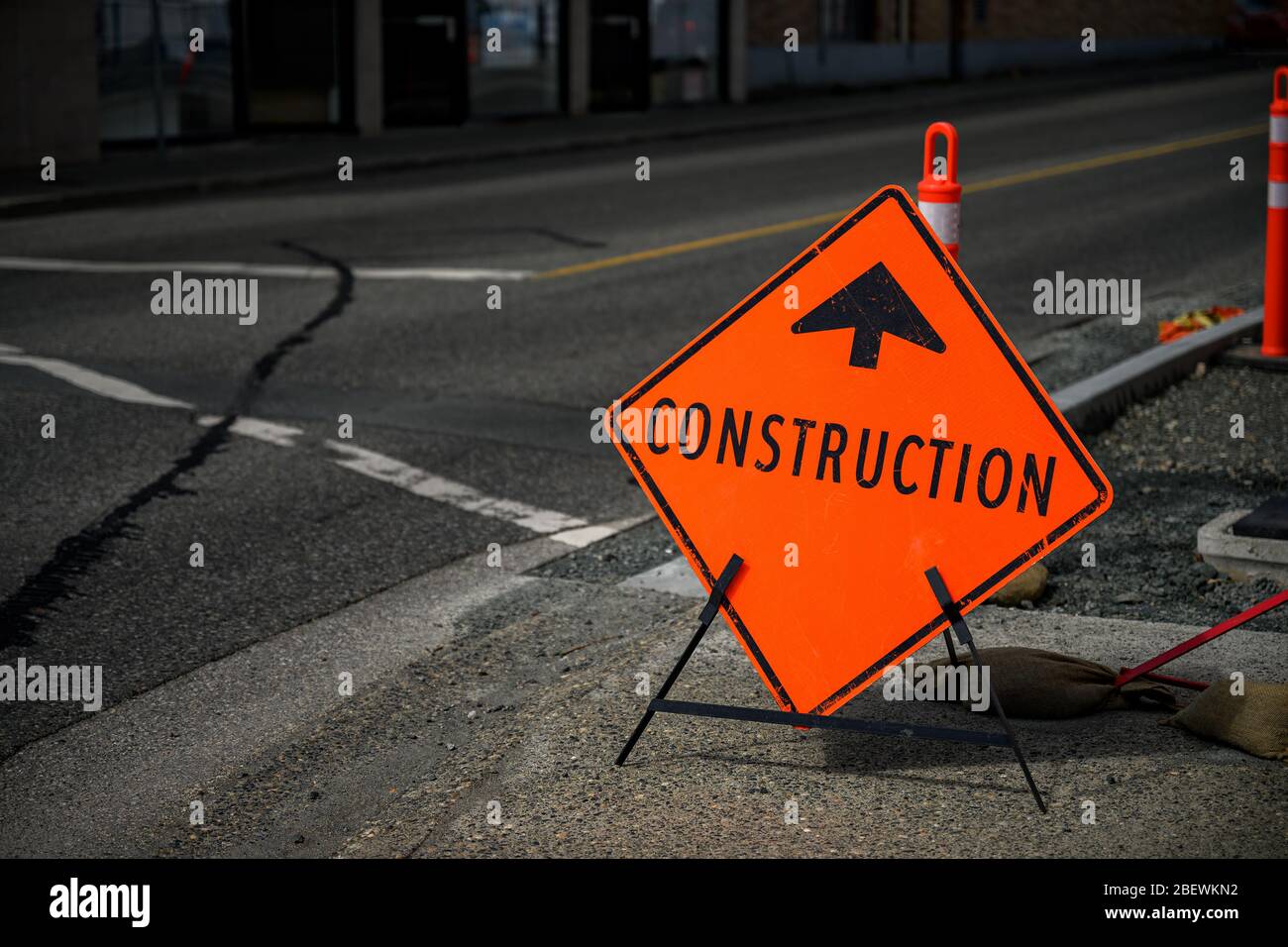 Bright orange construction sign on the street warns the traffic to be ...