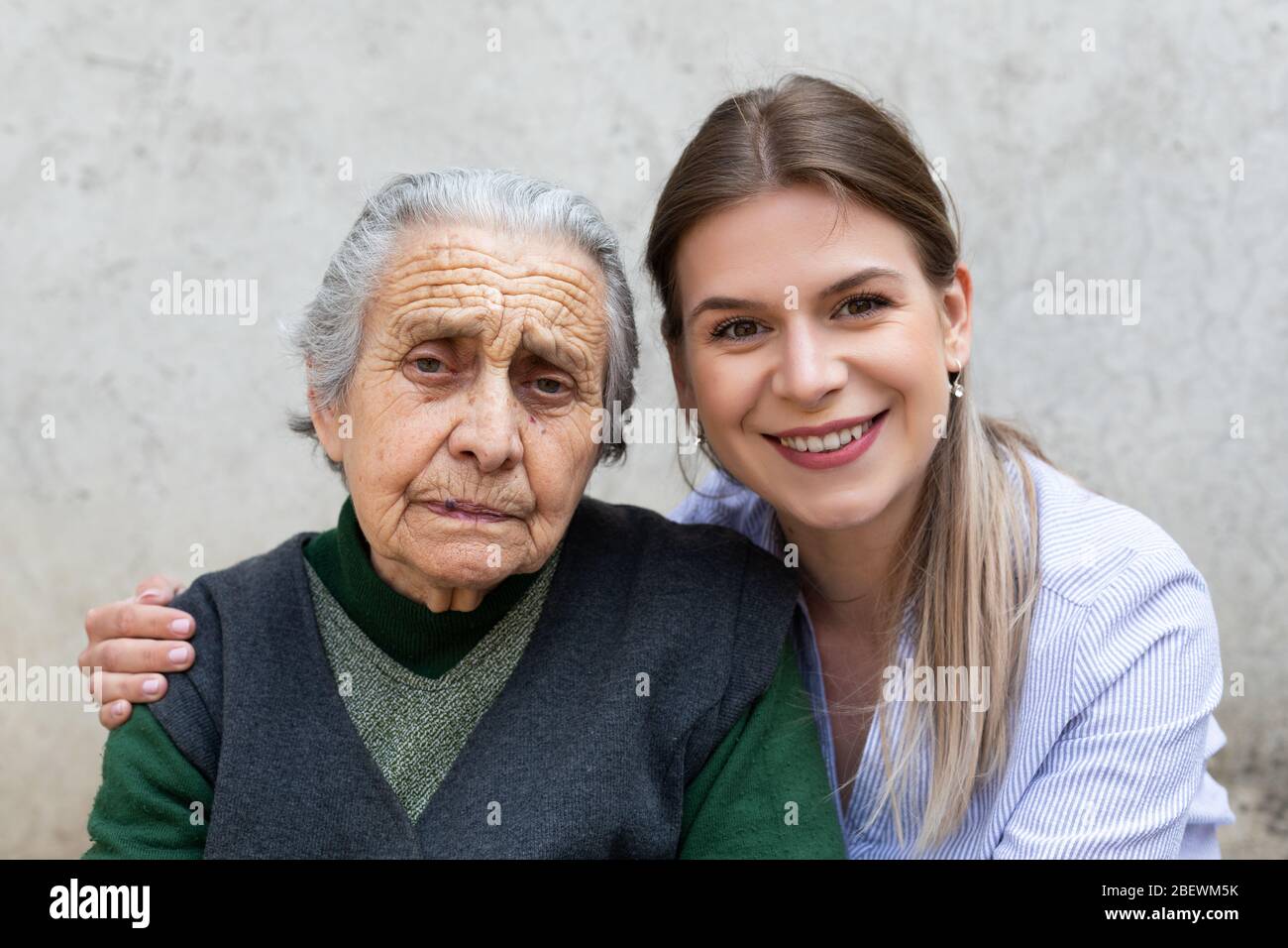 Young friendly woman embracing senior lady outdoor - quality time spent ...