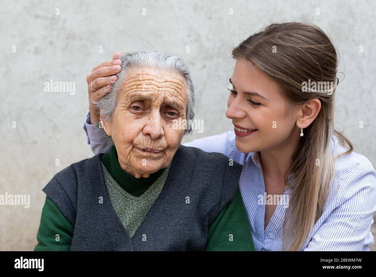 Young friendly woman embracing senior lady outdoor - quality time spent ...
