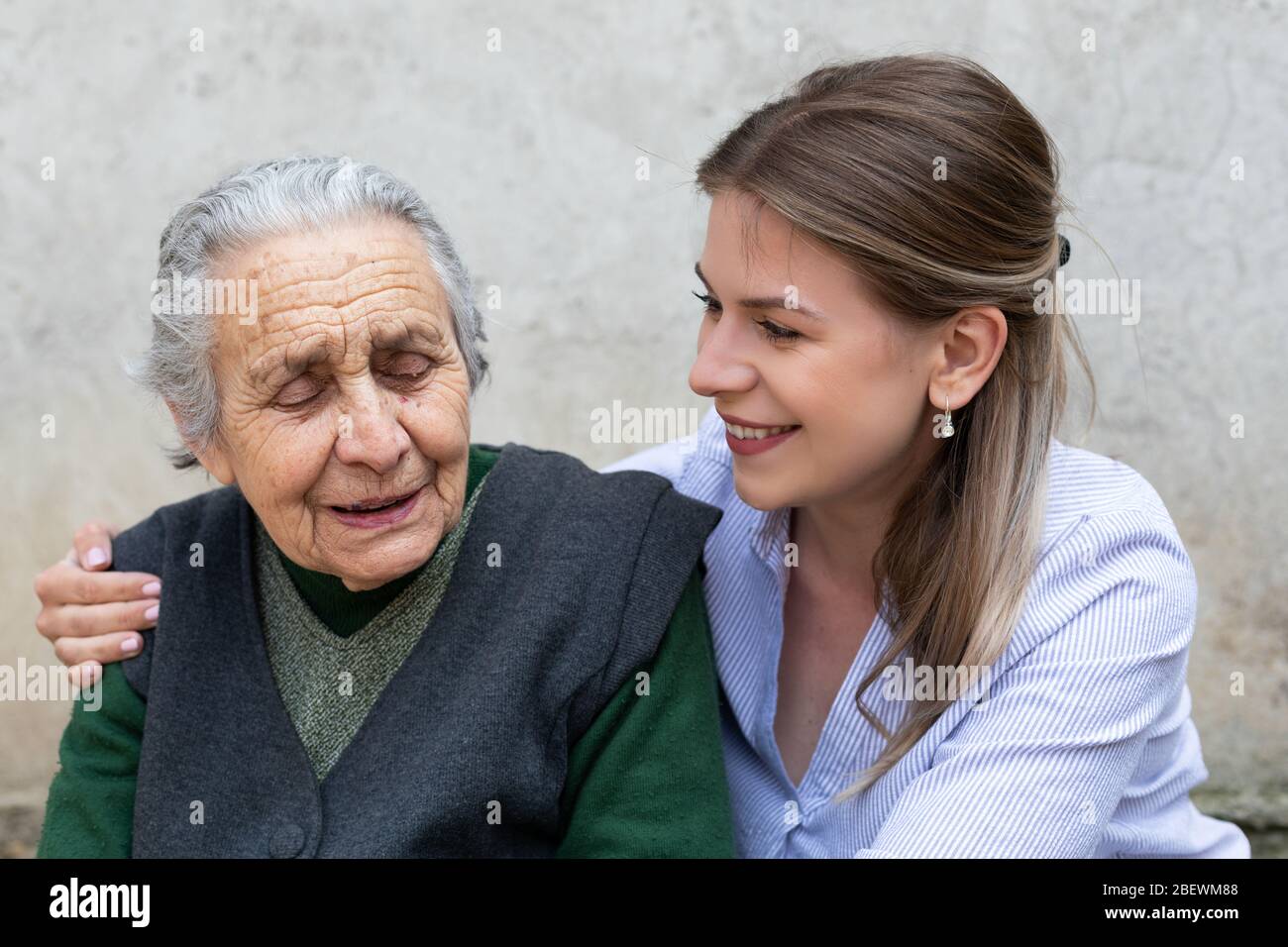 Young friendly woman embracing senior lady outdoor - quality time spent ...