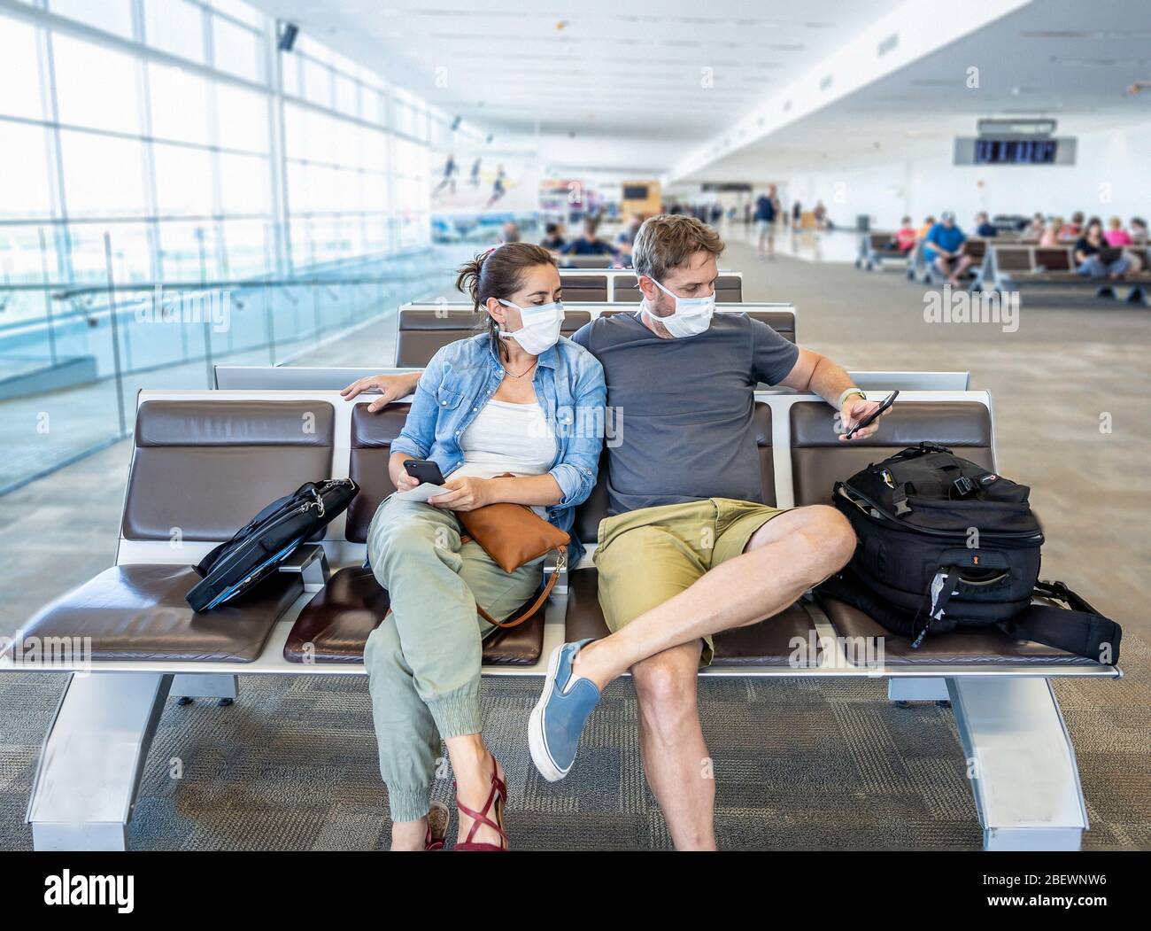 COVID-19 worldwide borders closures. Couple with face mask stuck in ...