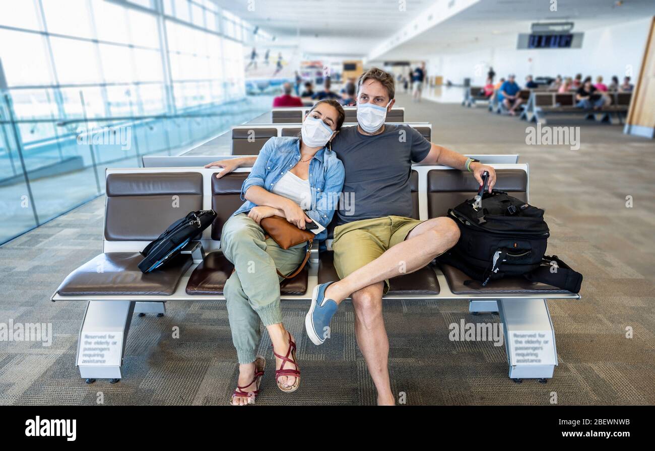 COVID-19 worldwide borders closures. Couple with face mask stuck in ...