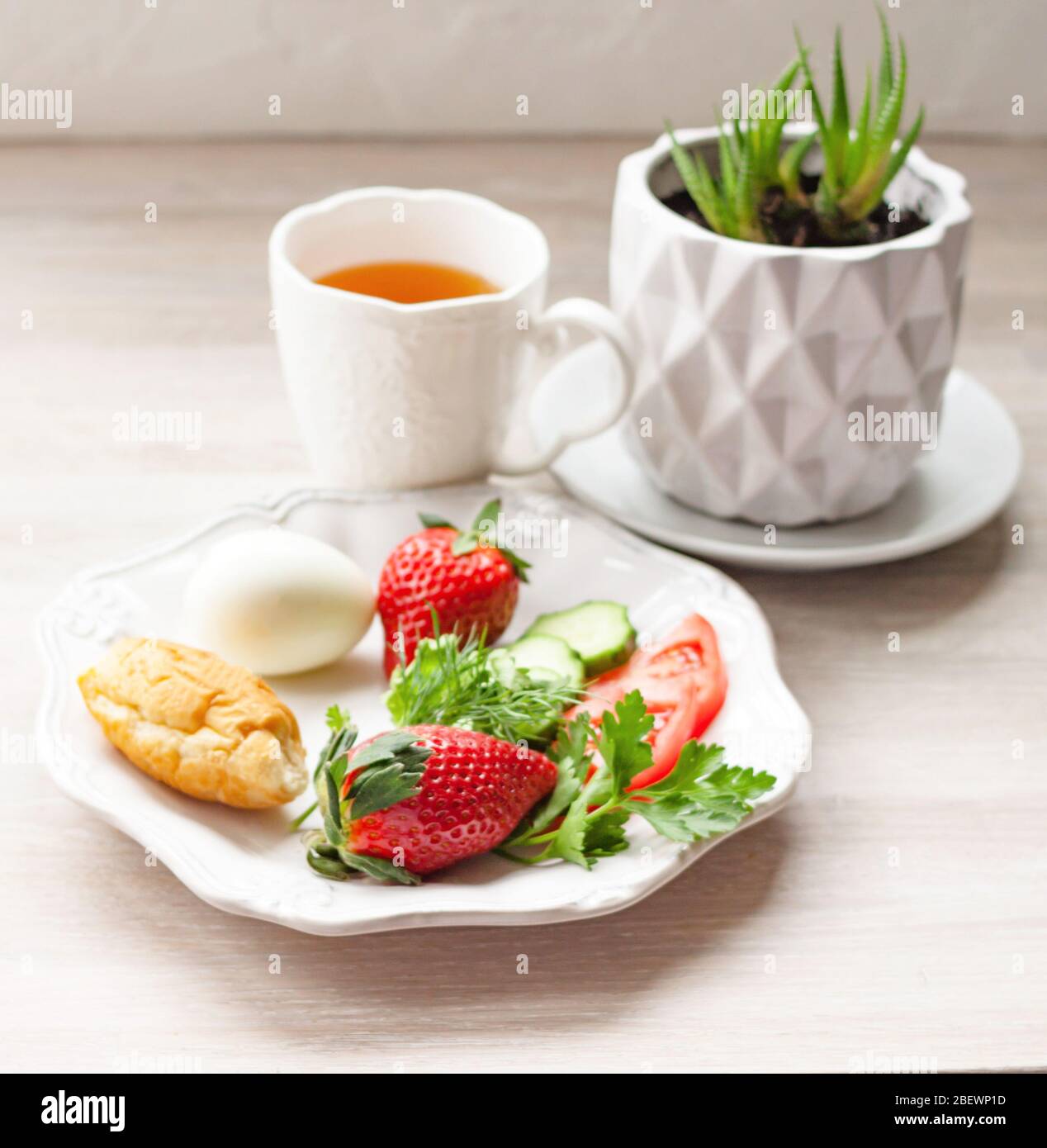 Spring healthy breakfast concept. Cup of tea, egg, croissant, fresh ...