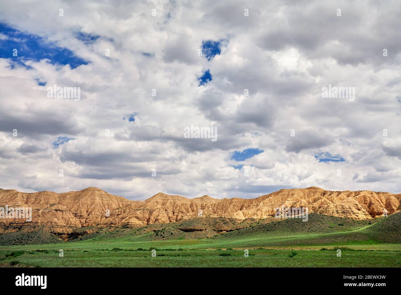 Yellow mountains of moon canyon in green steppe in Kazakhsthan Stock ...