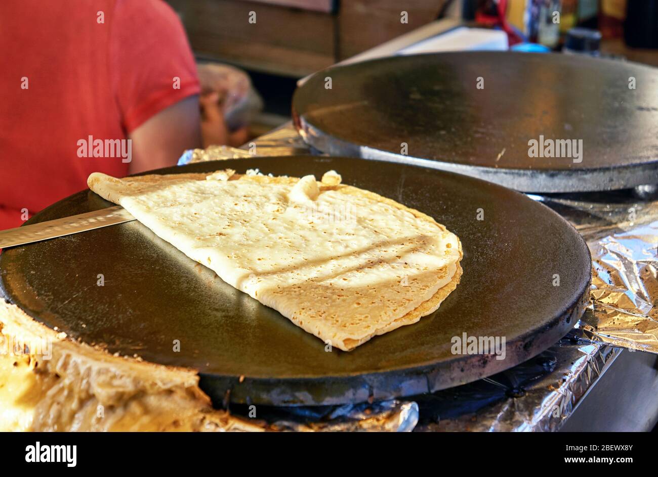 Preparation of crepes pancakes on a hot metal plate Stock Photo - Alamy
