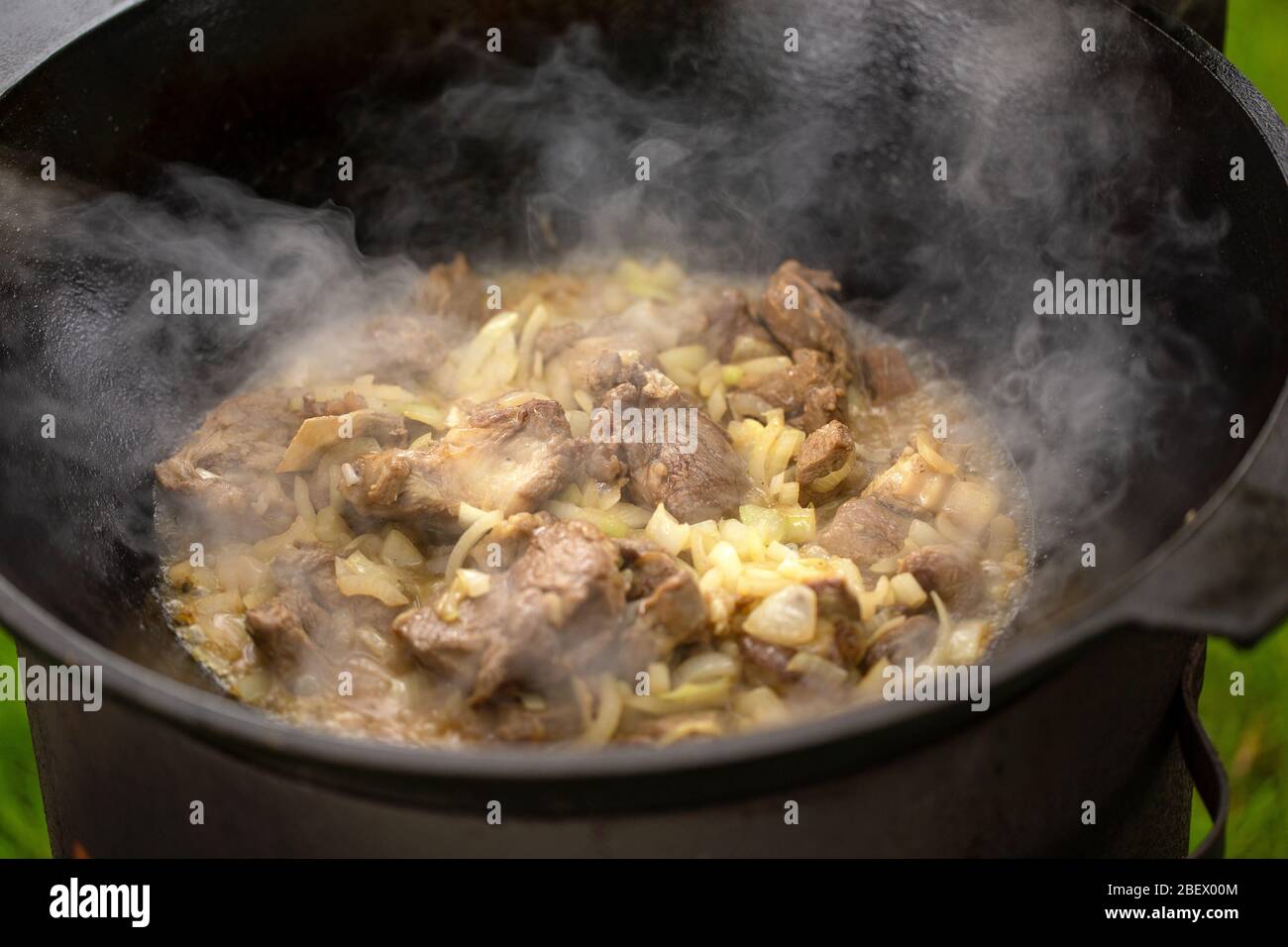 Cooking mutton meat with onion for pilaf. Meat fried in cast iron ...