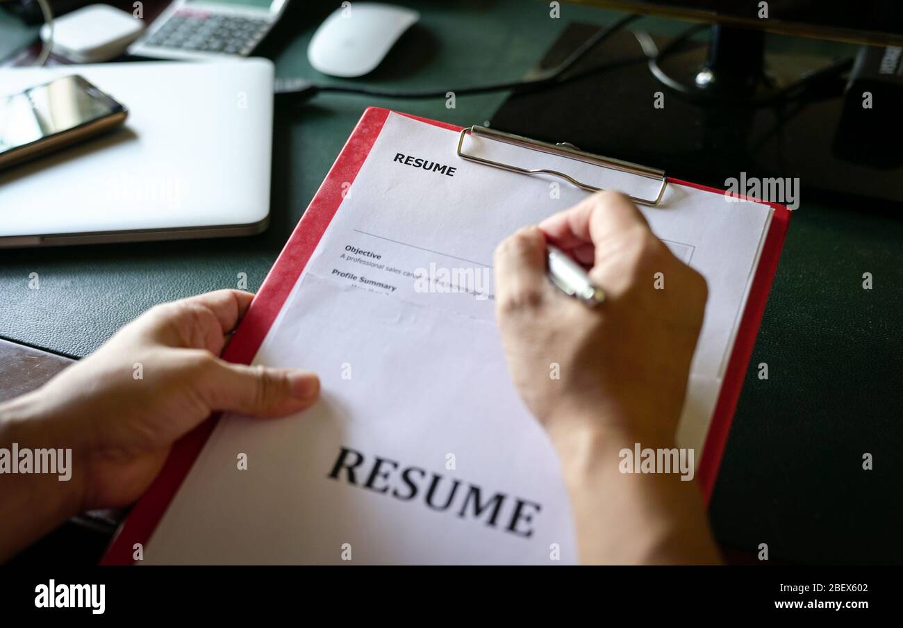 Closeup view of Hiring Manager reviewing resume at his office desk ...