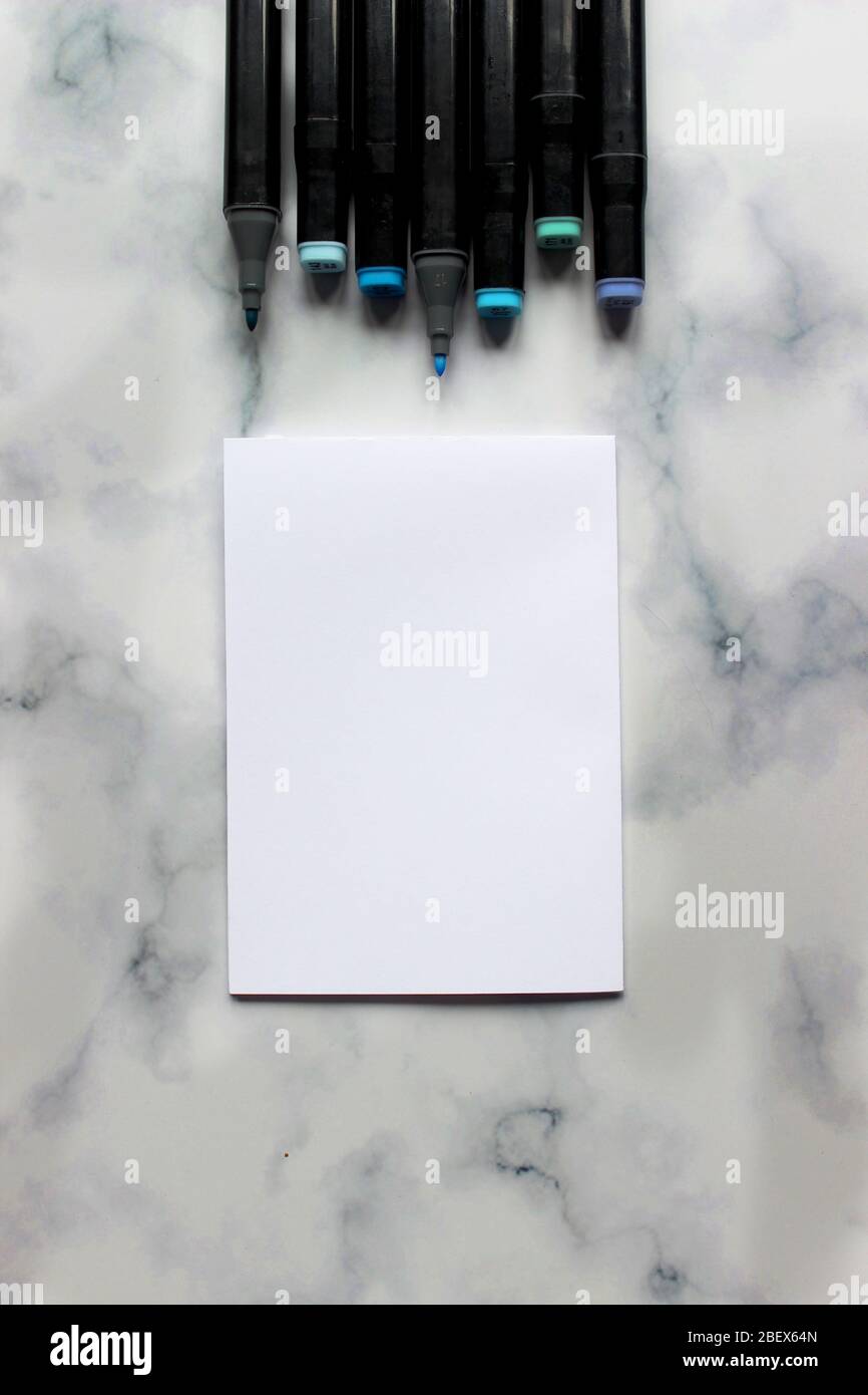 Marble background. Markers of blue shades and a sheet of paper. Sheet ...