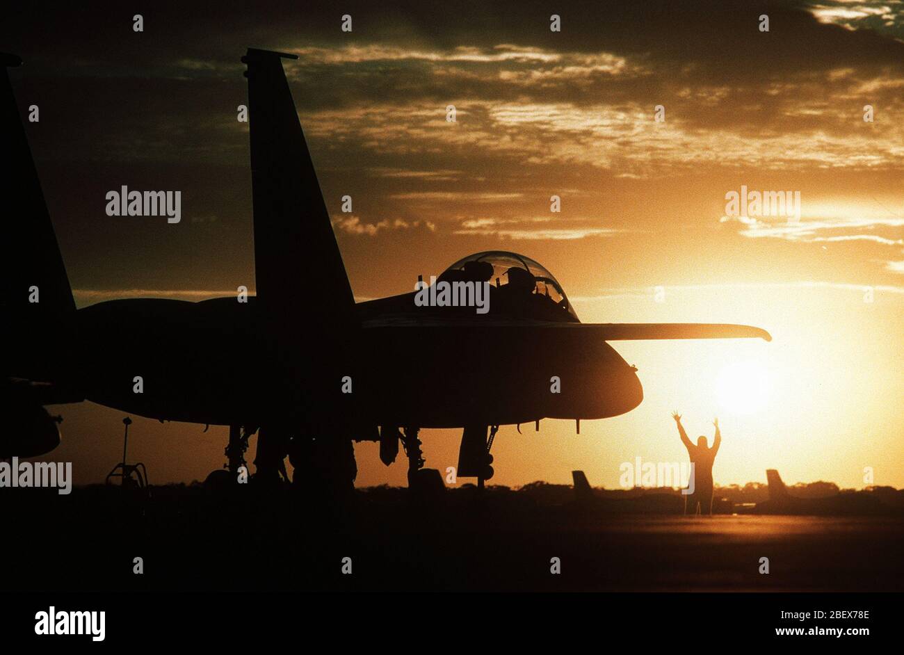 1981 - An eye-level view of an F-15 Eagle aircraft being marshalled by ...