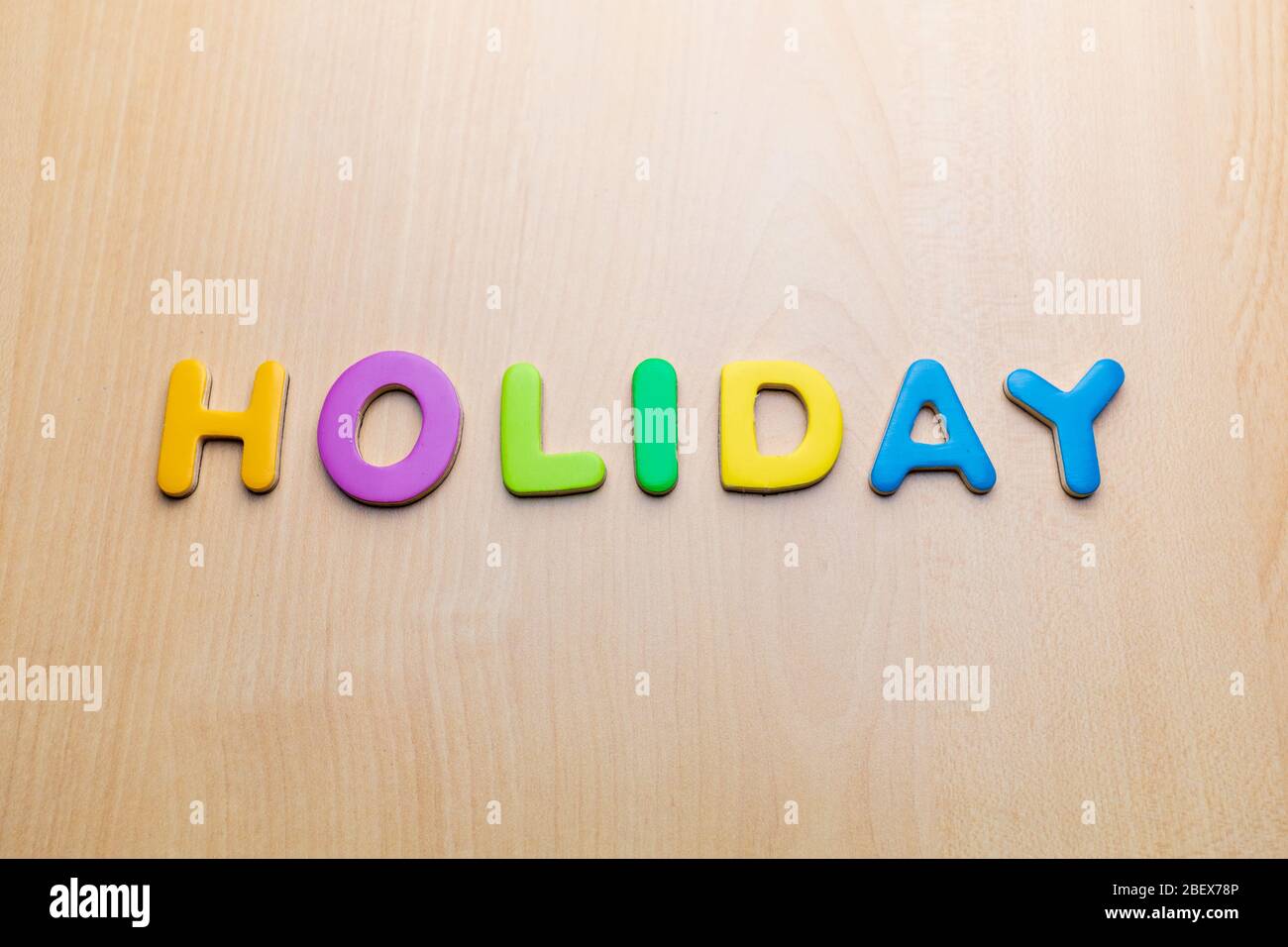 holiday word written with colorful letters on wooden table background ...