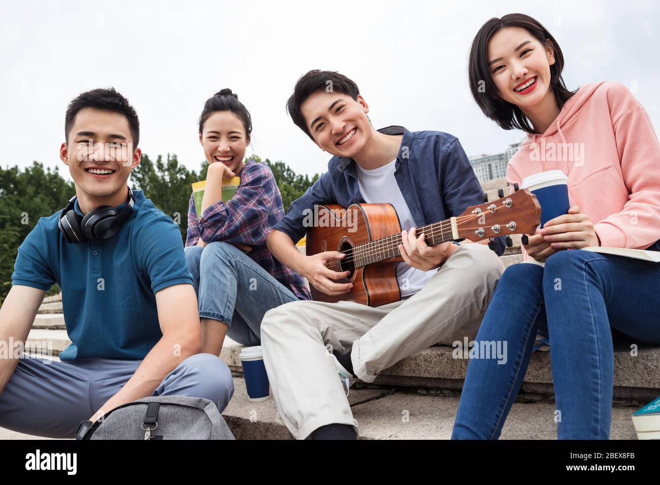 The young college students playing sat on the steps Stock Photo - Alamy