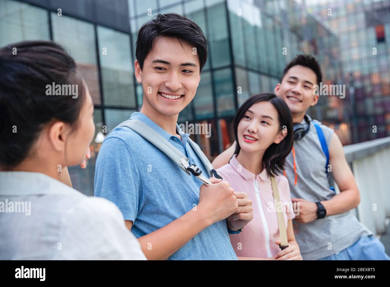 Outdoor four college students chatting together Stock Photo - Alamy