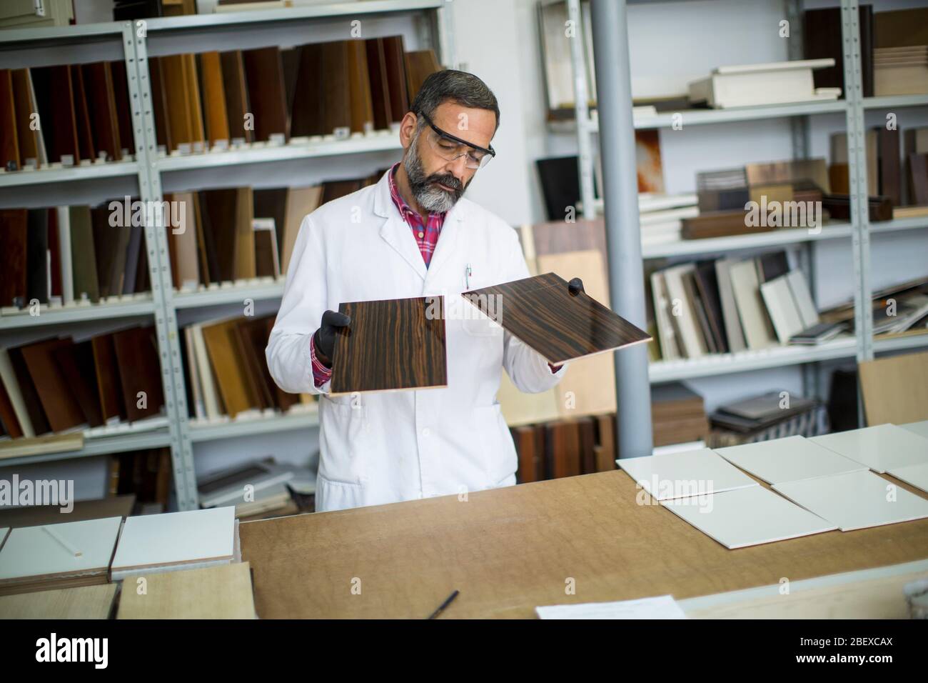 View at handsome mature engineer in the laboratory examines ceramic ...