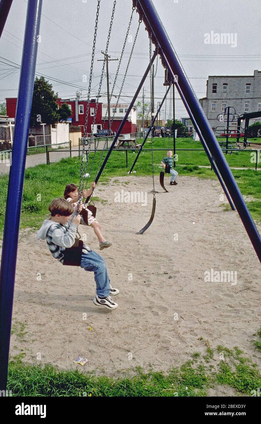 June 11, 1998 - children playing in playground on swingset in urban ...