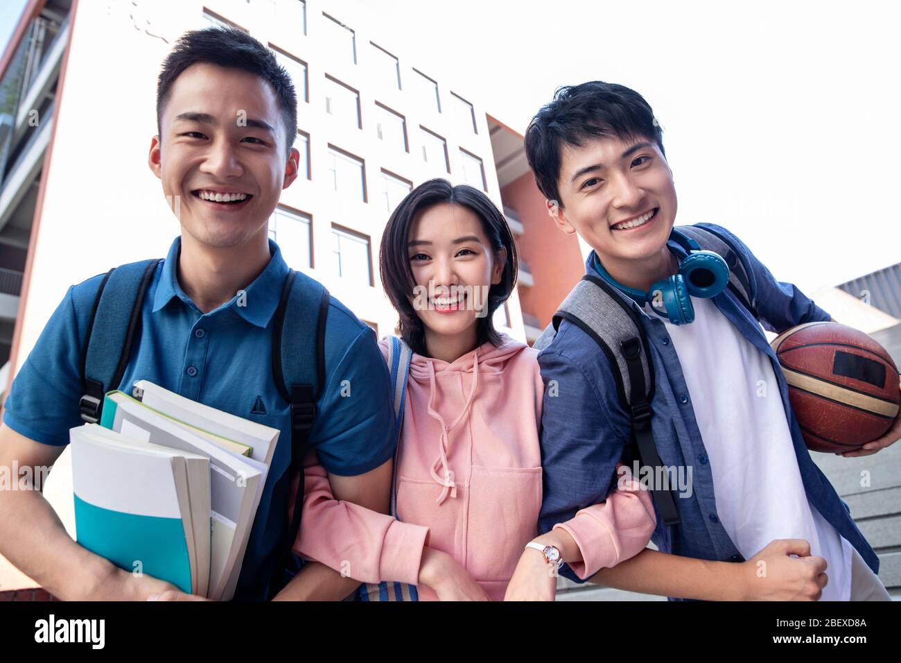 Campus happy three college students holding together Stock Photo - Alamy
