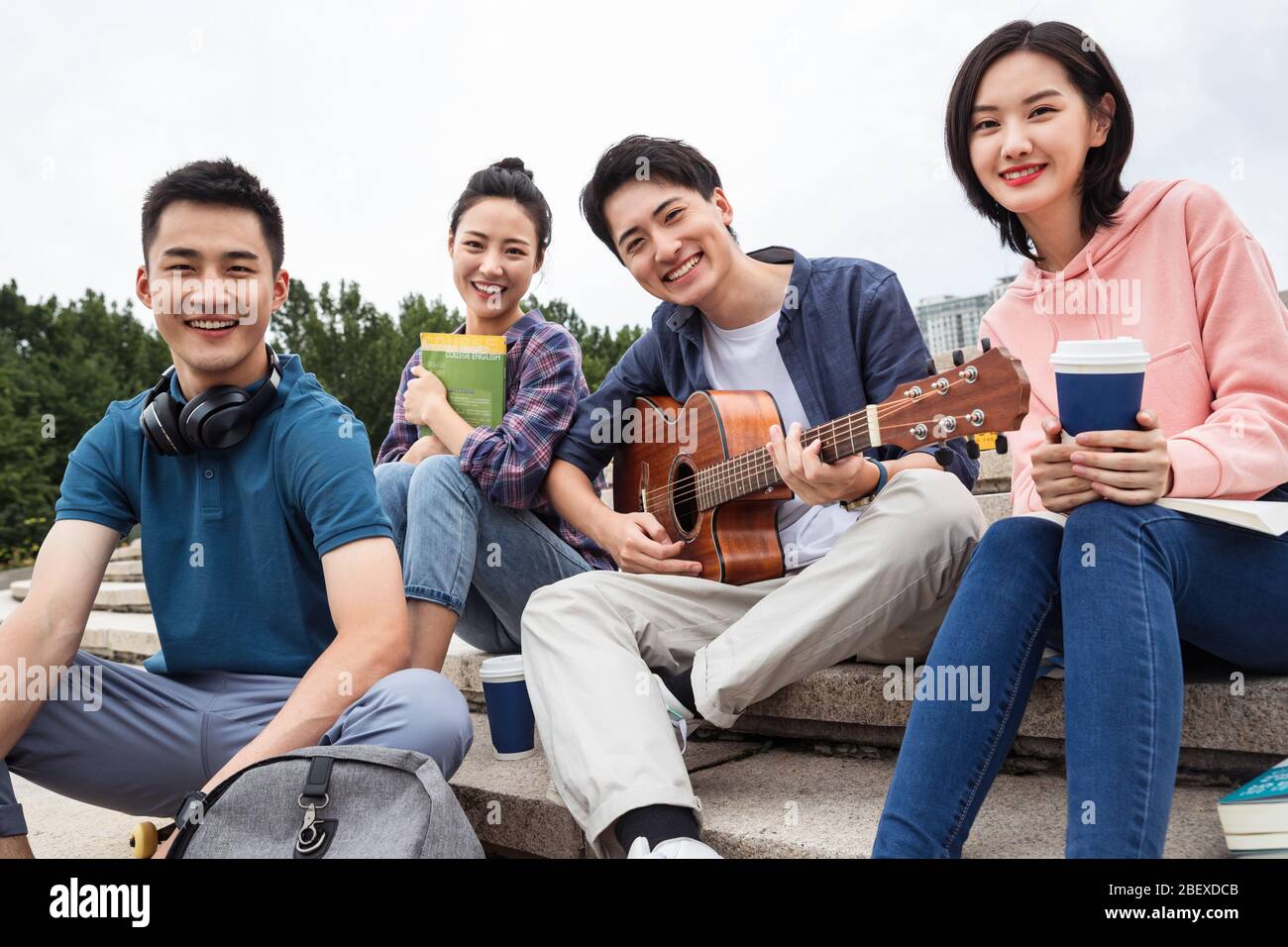 The young college students playing sat on the steps Stock Photo - Alamy