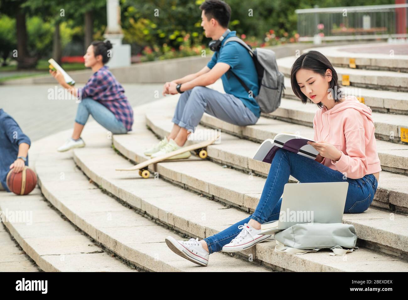 Happy college students sat on the steps of learning Stock Photo - Alamy