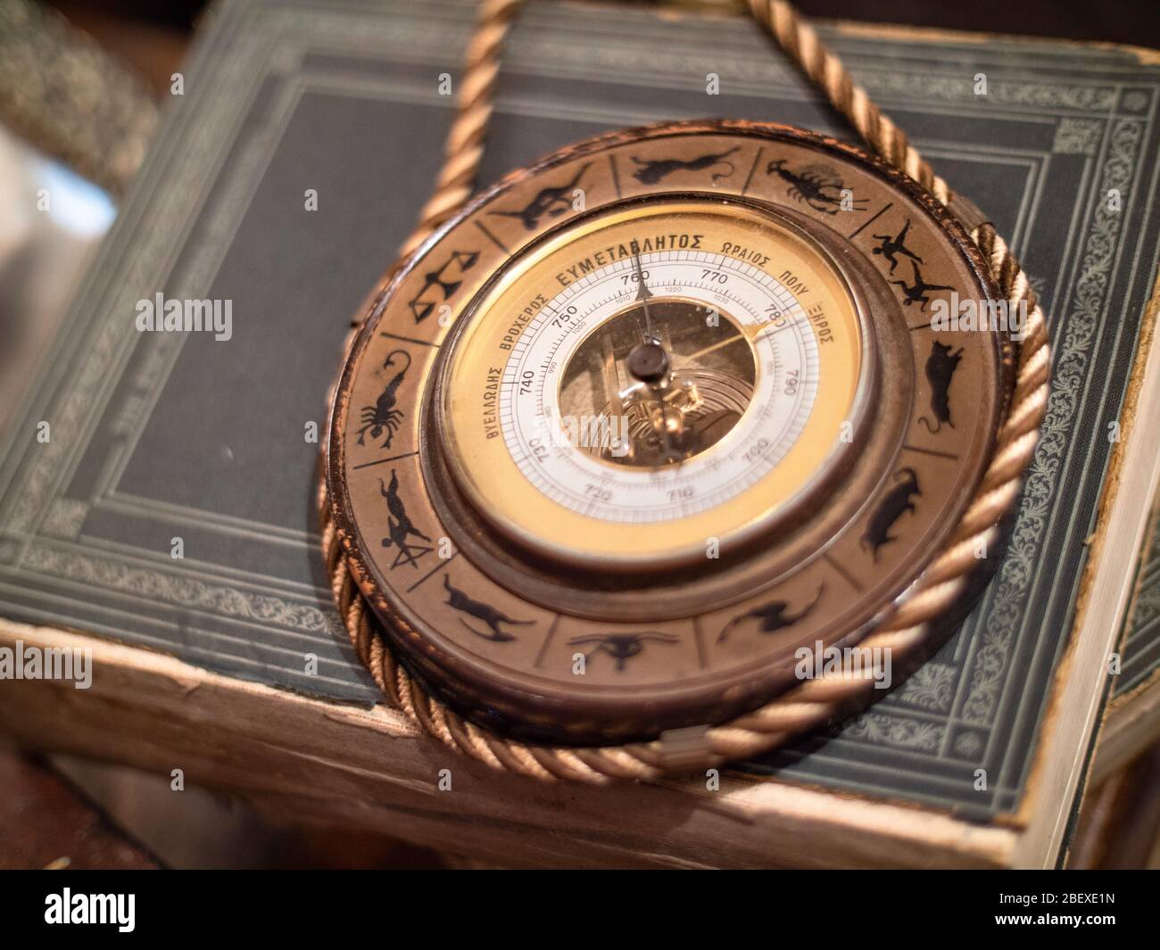 an antique barometer wth zodiac symbols on a book Stock Photo - Alamy