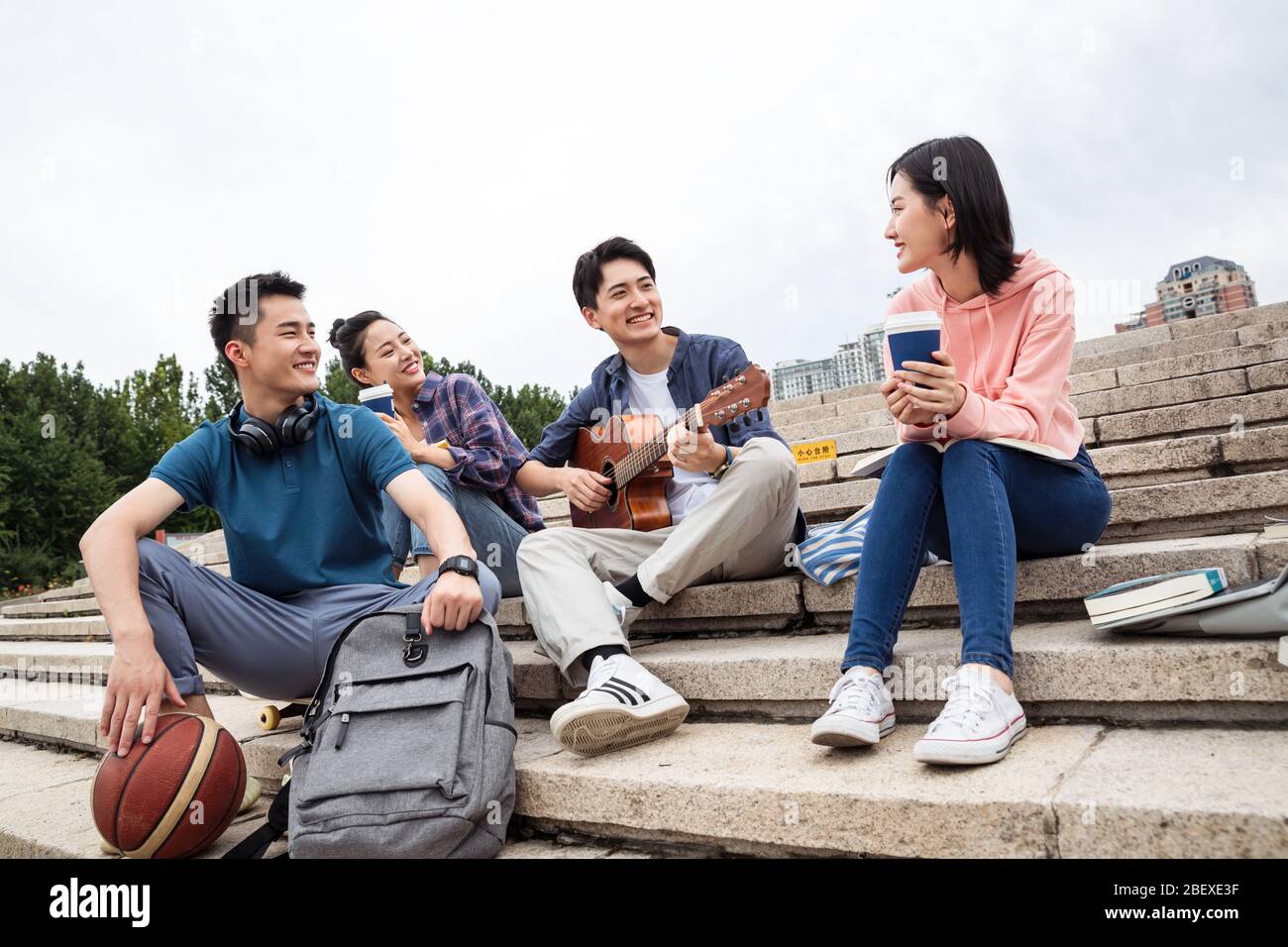 The young college students sat on the steps to play guitar Stock Photo ...