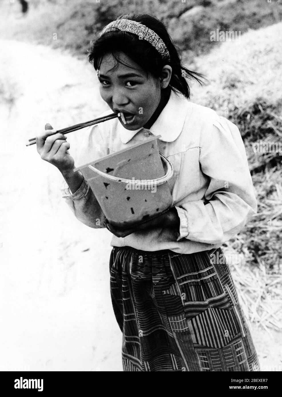 In the 1990s a girl in a small bucket serving rice in rural Henan Stock ...