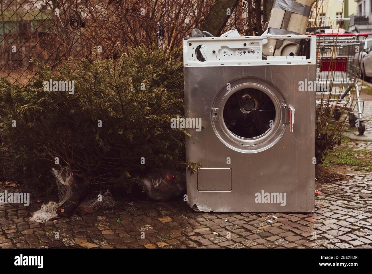 Old washing machine standing on the sidewalk, junk on the street ...