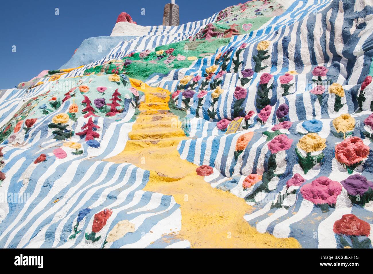 Yellow trail going up the colourful hills of the Salvation Mountains ...