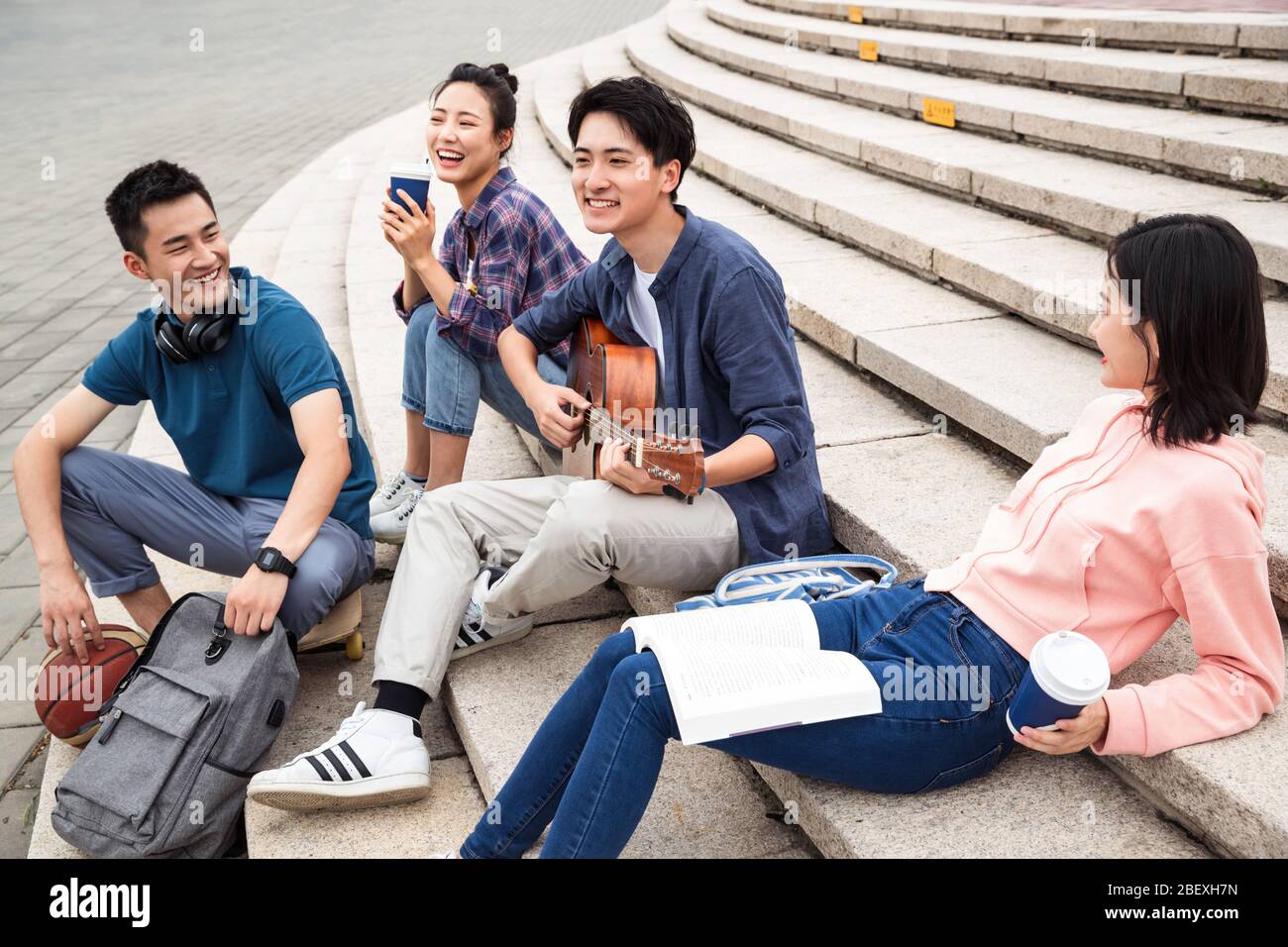 The young college students sat on the steps to play guitar Stock Photo ...