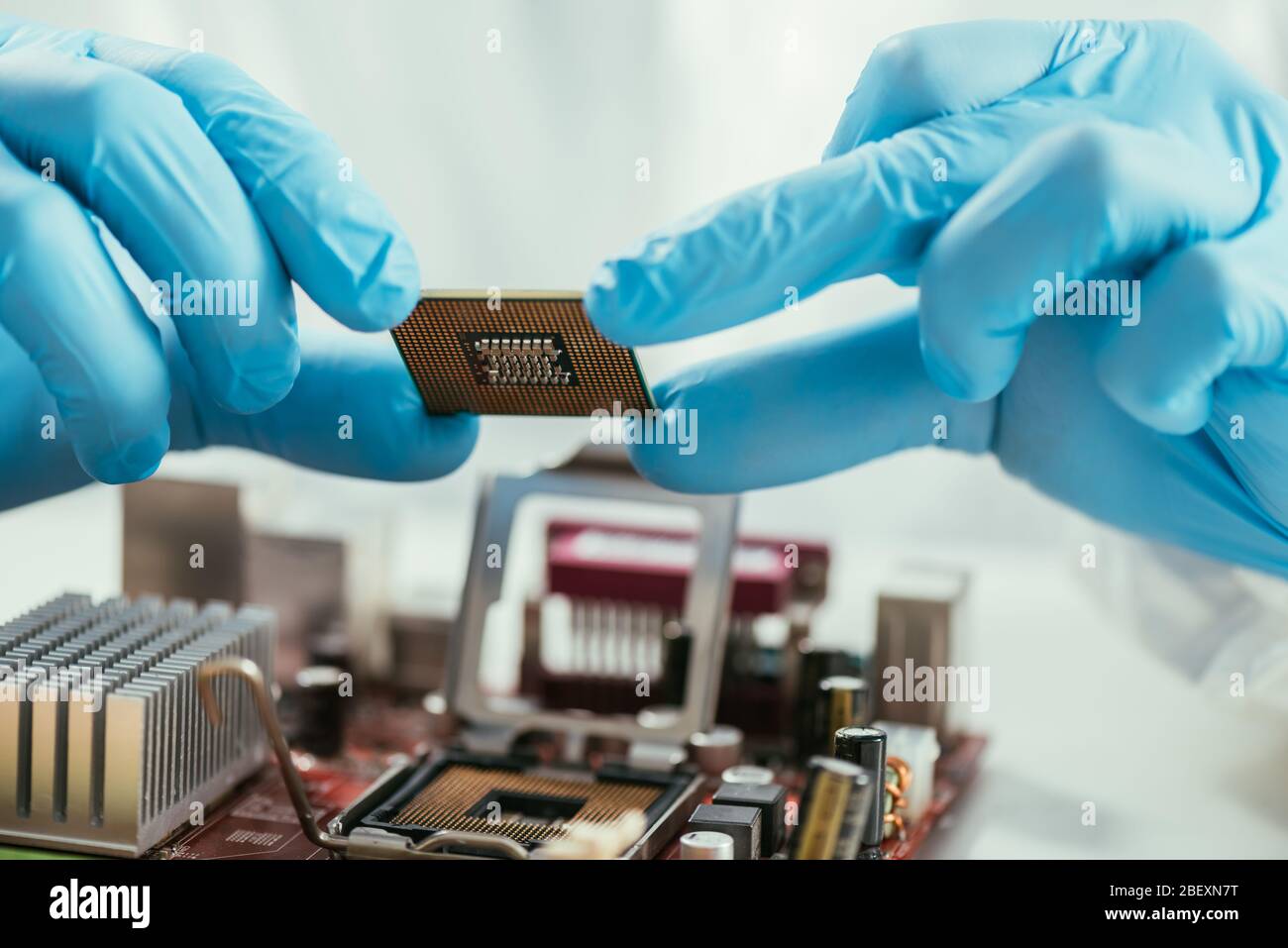 Partial View Of Engineer Holding Microchip Near Computer Motherboard