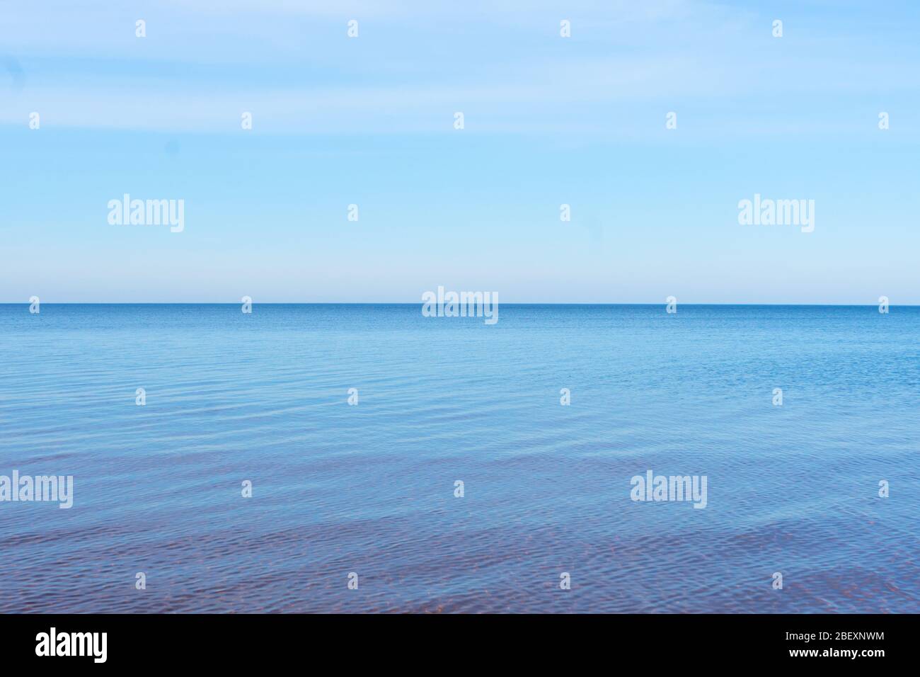 selective focus, flat horizon line, blue lake with cloudy sky in the ...
