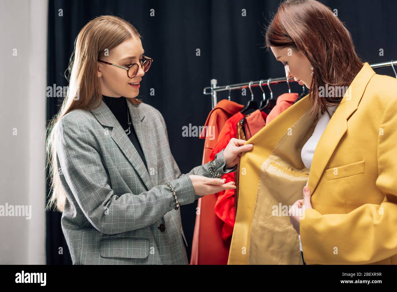 Stylist touching jacket on model hi-res stock photography and images ...