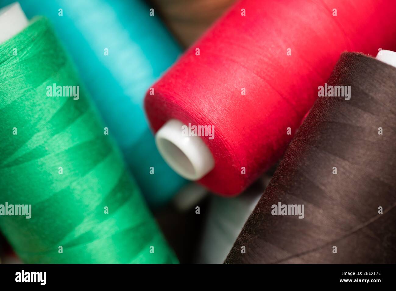 Different thread colors on large bobbins scattered randomly in a box ...