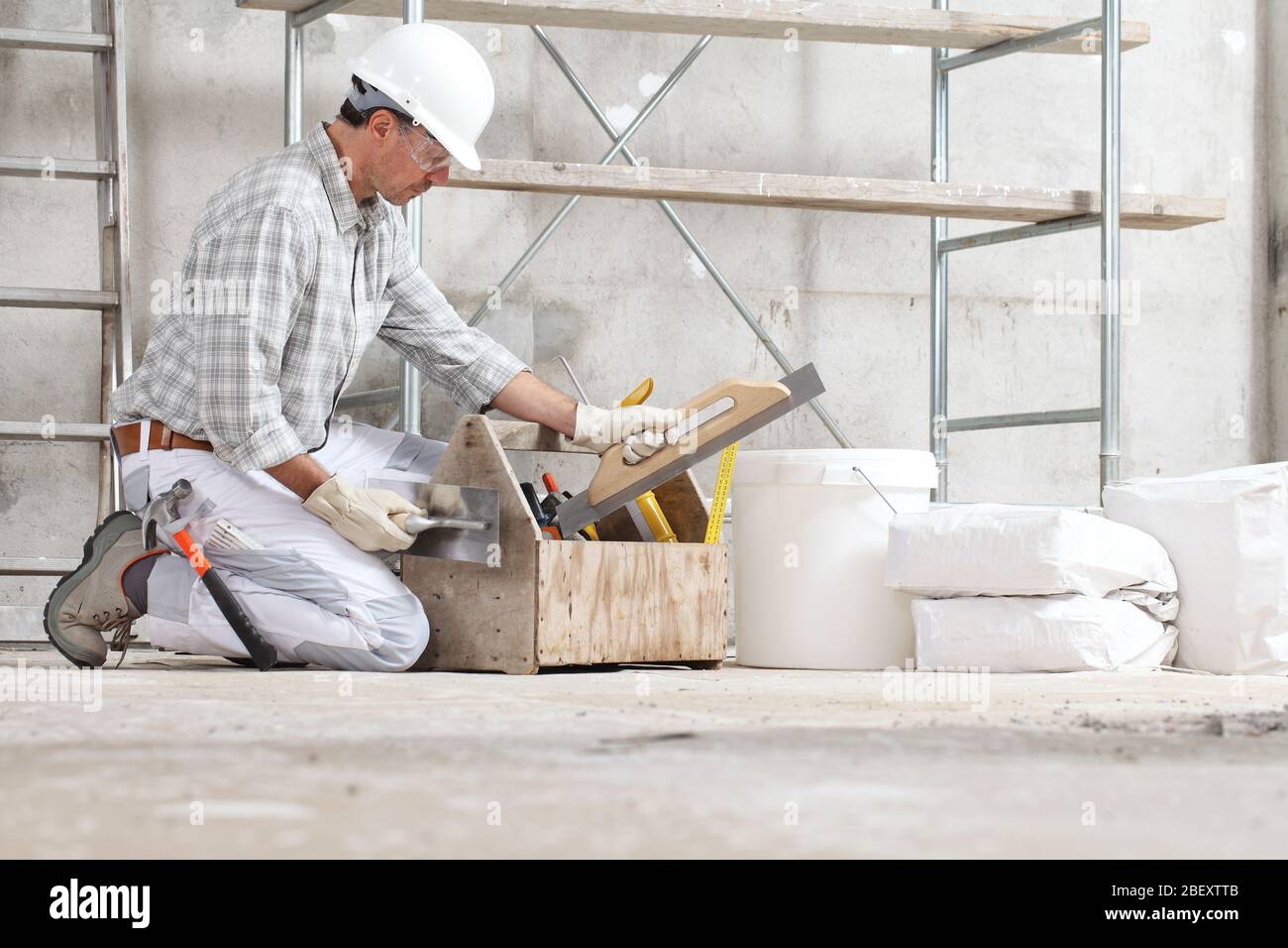 plasterer man construction worker takes the plaster trowel from the ...