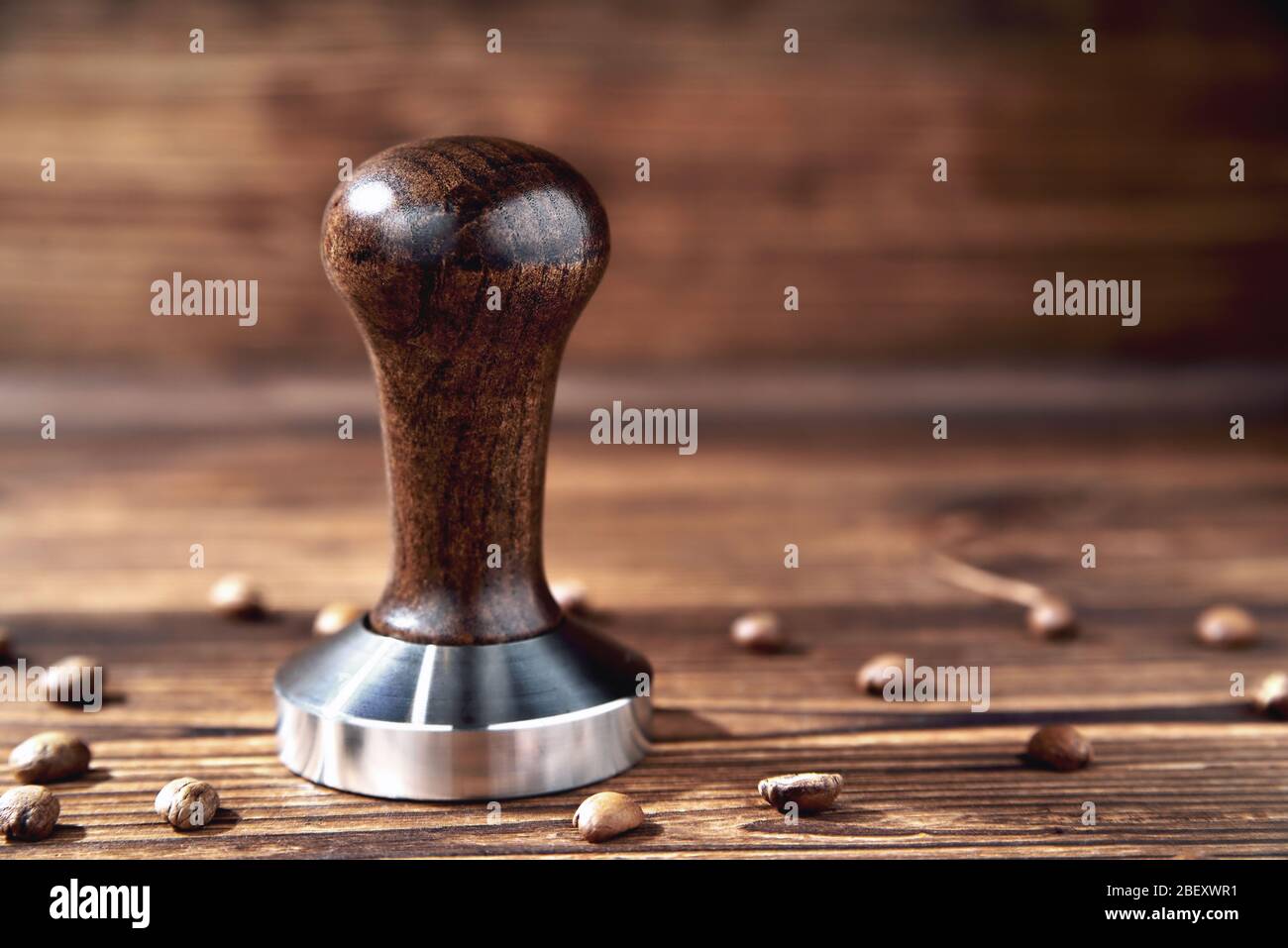 temper coffee beans on a brown wooden background blur Stock Photo - Alamy