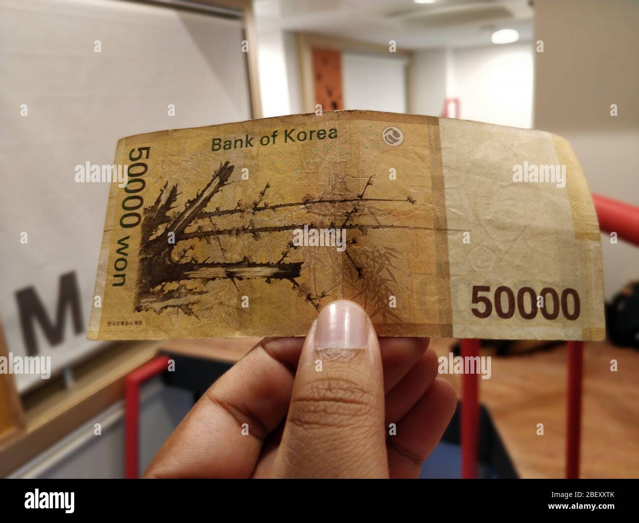 Man holds a 50,000 South Korean Won bank note, currently in circulation ...