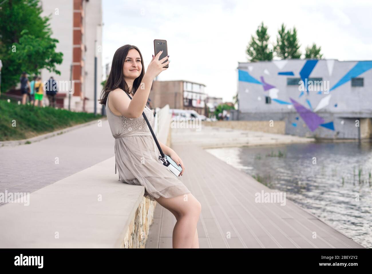 Girl with phone on pier. Pretty girl taking selfies in the city Stock ...