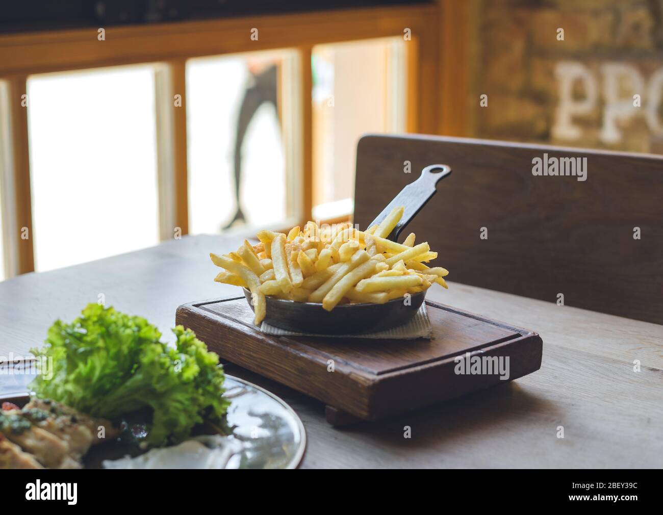 French fries in pan on wooden table Stock Photo - Alamy