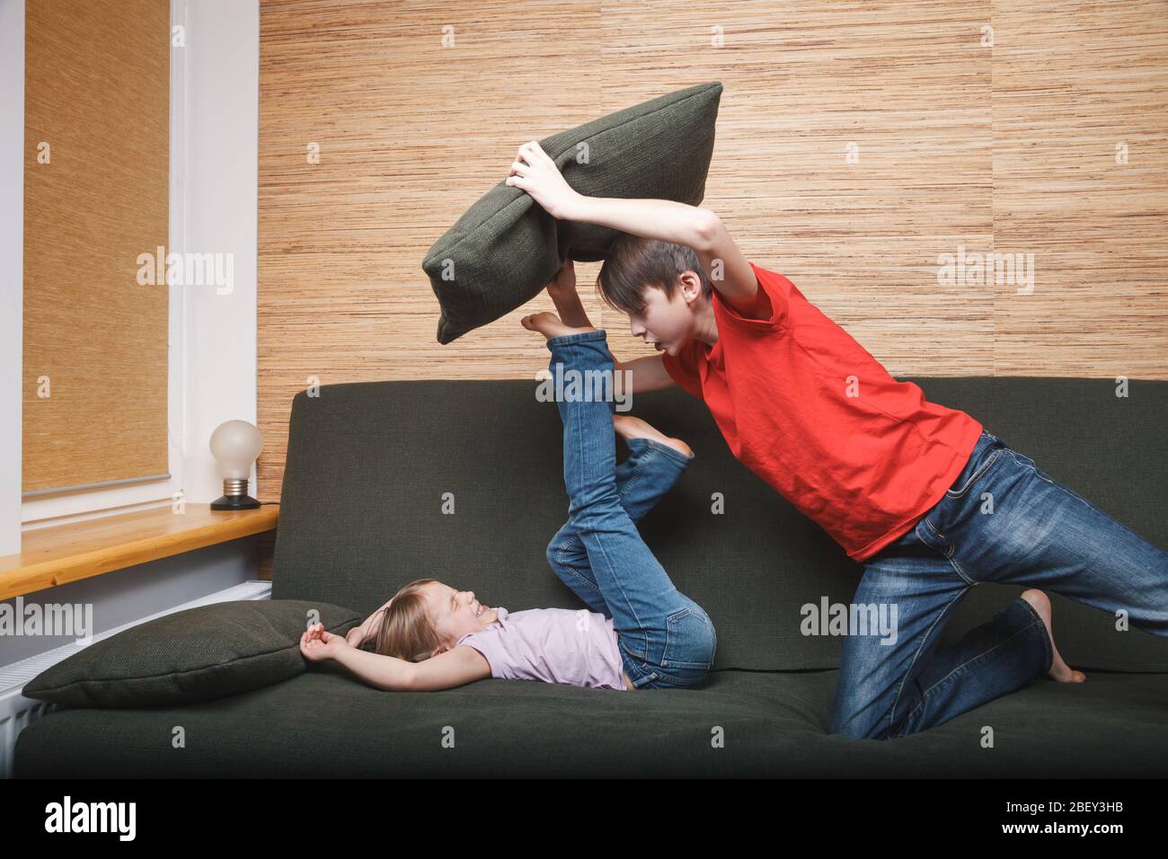 Siblings fighting with pillows stuck at home being in self-isolation ...