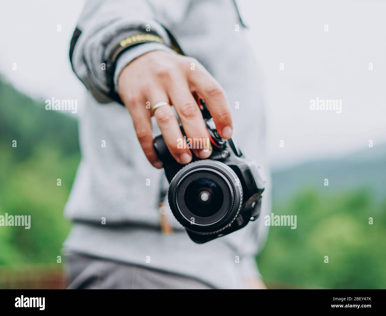 Male hand holding a camera. Photographer man Stock Photo - Alamy