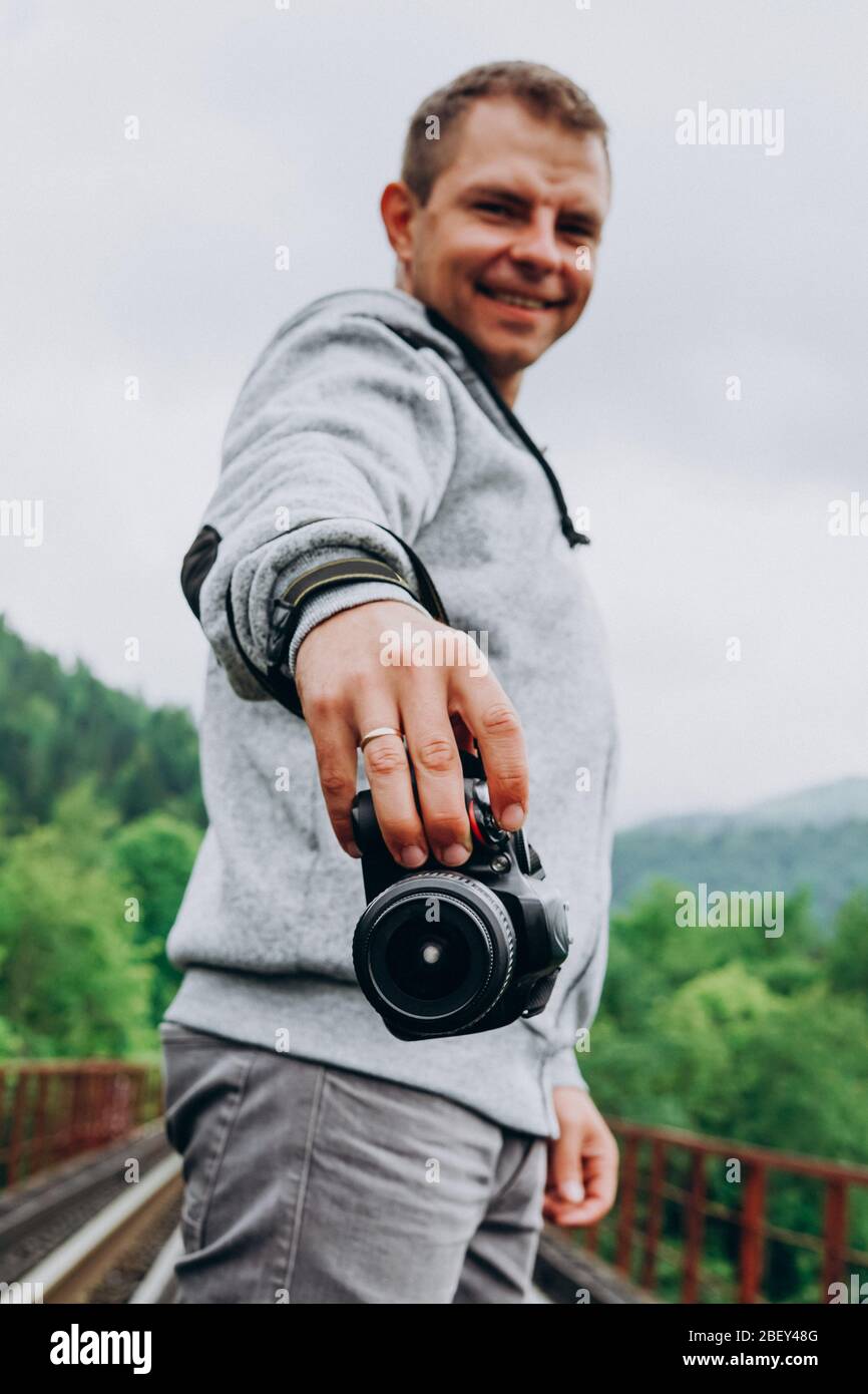 Man photographer holding his camera. Photographer with camera on forest ...