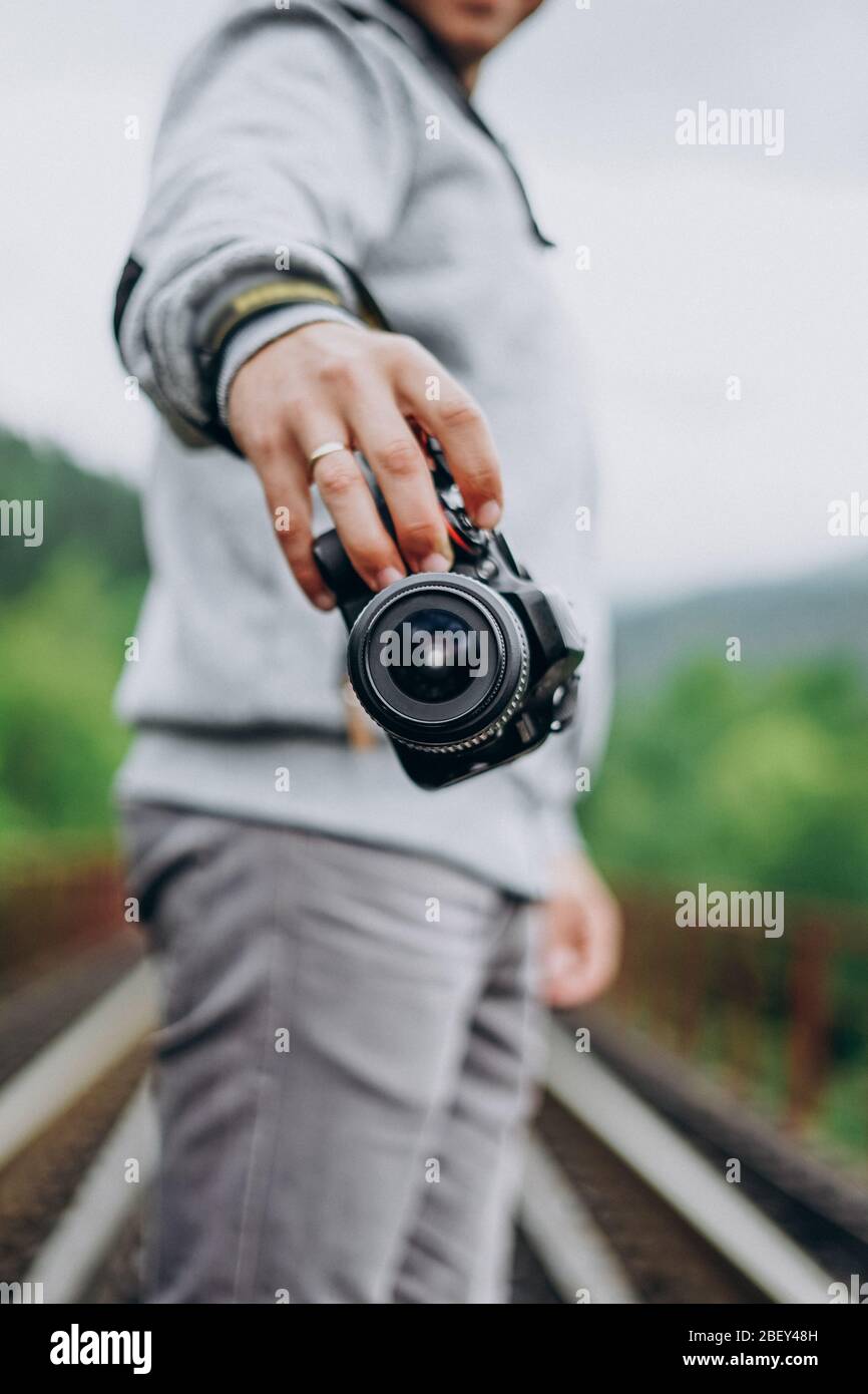 Male hand holding a camera. Photographer man Stock Photo - Alamy
