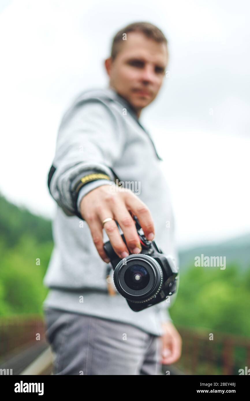 Man photographer holding his camera. Photographer with camera on forest ...
