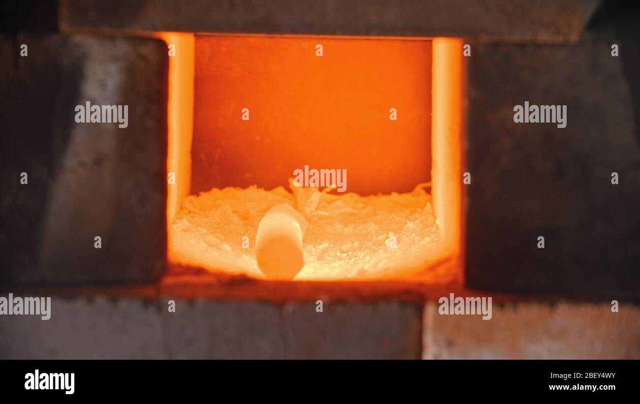 Heating up a round piece of metal. Mid shot Stock Photo - Alamy