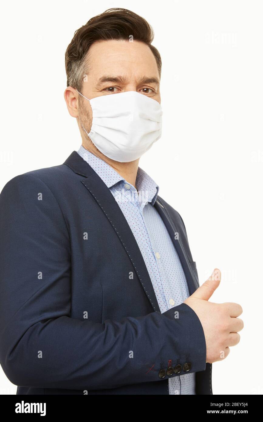 Businessman with a mask. Protection is important. Thumbs up Stock Photo ...