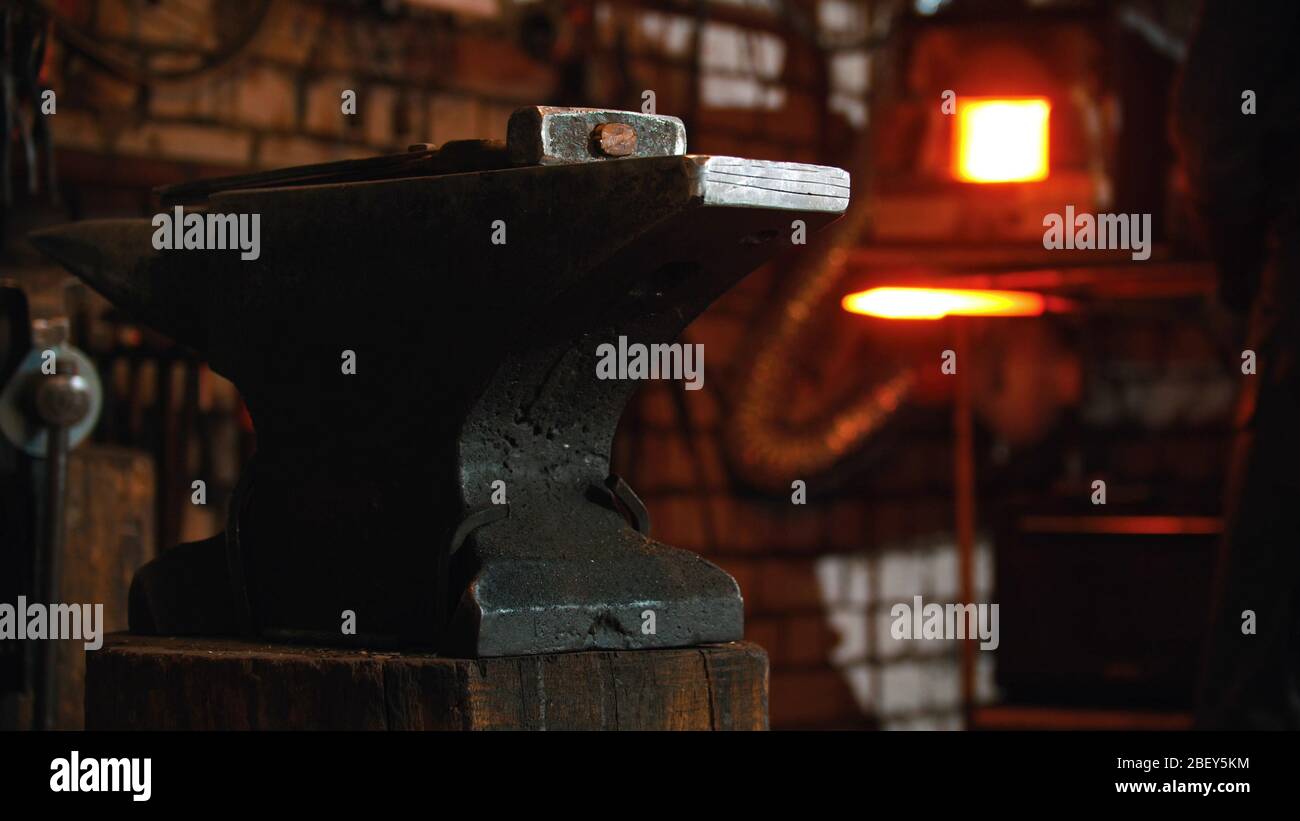 Forging industry indoors with working blacksmith - hammer on the anvil ...